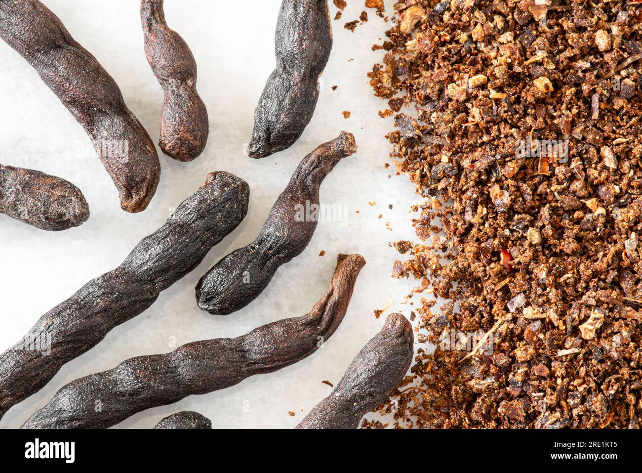 Close-up of elongated African black pepper pods on a white marble ...