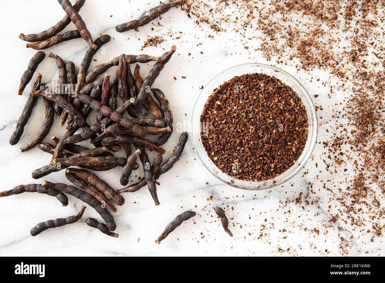Close-up of elongated African black pepper pods on a white marble ...