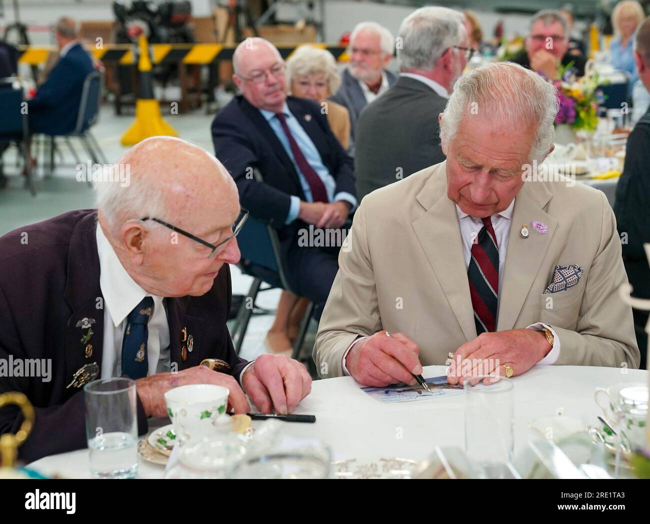 King Charles III (right) autographs a picture of a Lancaster bomber for ...