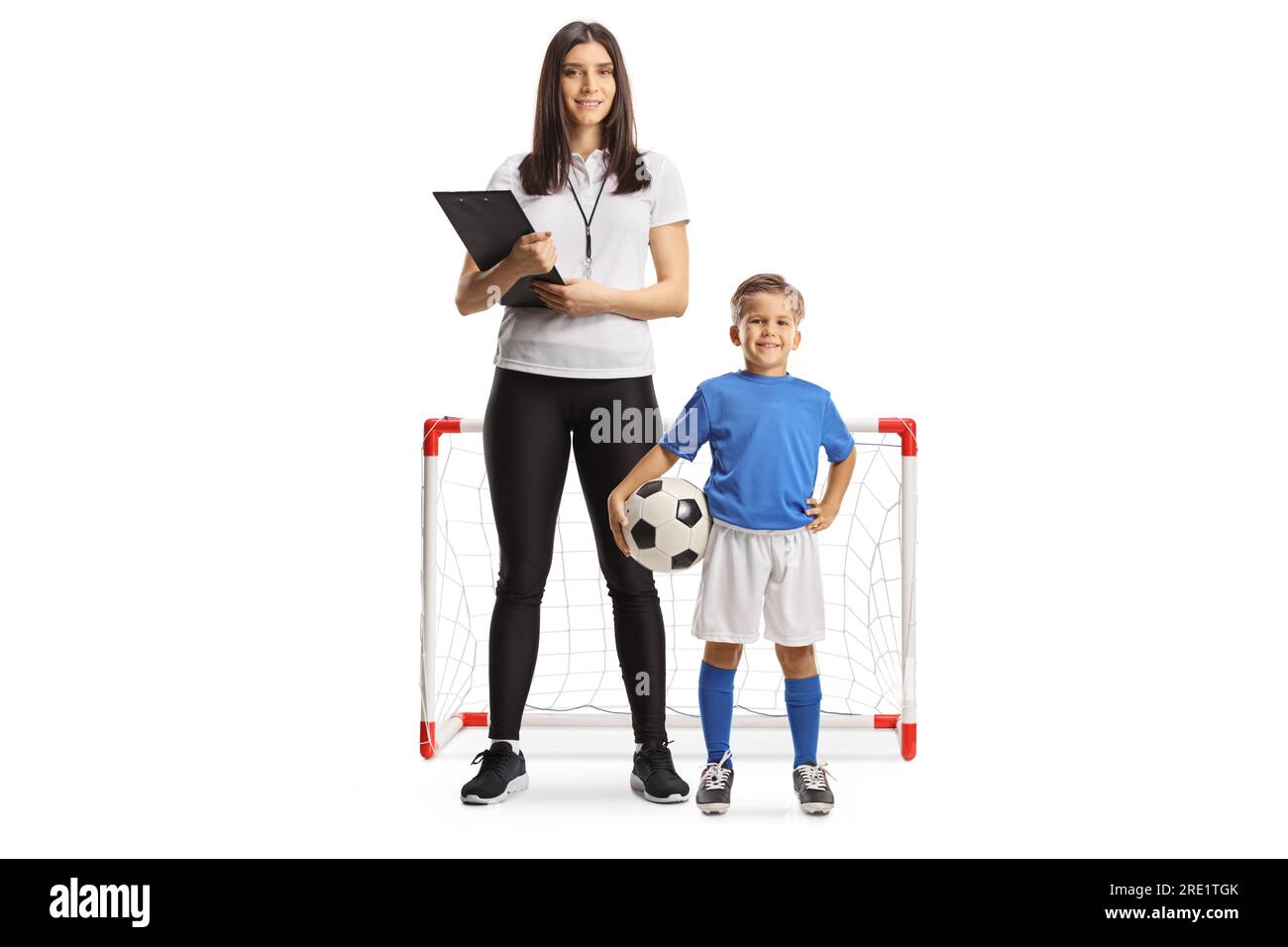 Boy with a female football coach posing in front of a mini goal ...