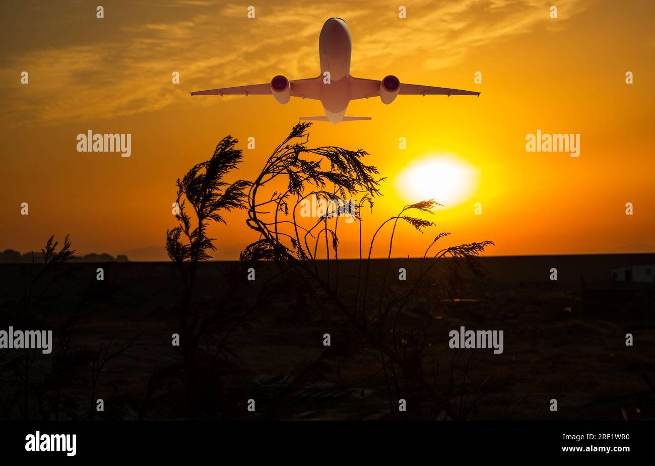 passenger plane fly up over take-off runway from airport at sunset ...