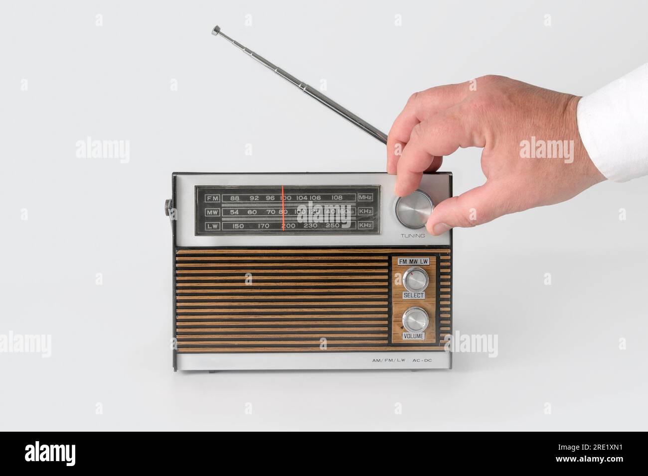 Authentic 70s radio receiver. With a man's hand on the wave-tuning ...