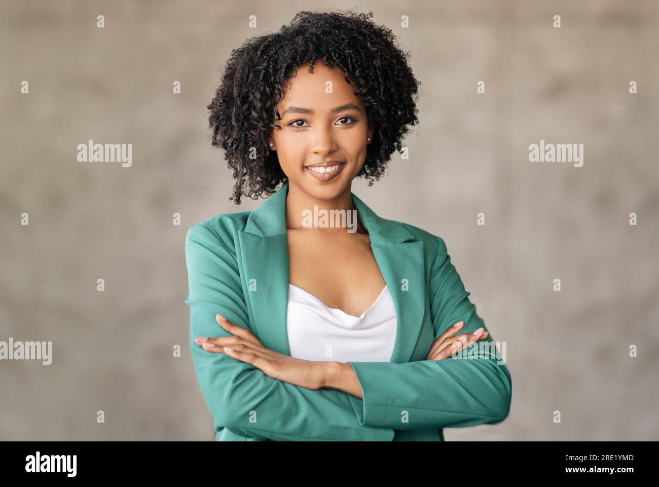 Happy Black Businesswoman Crossing Hands Over Gray Office Wall Stock ...