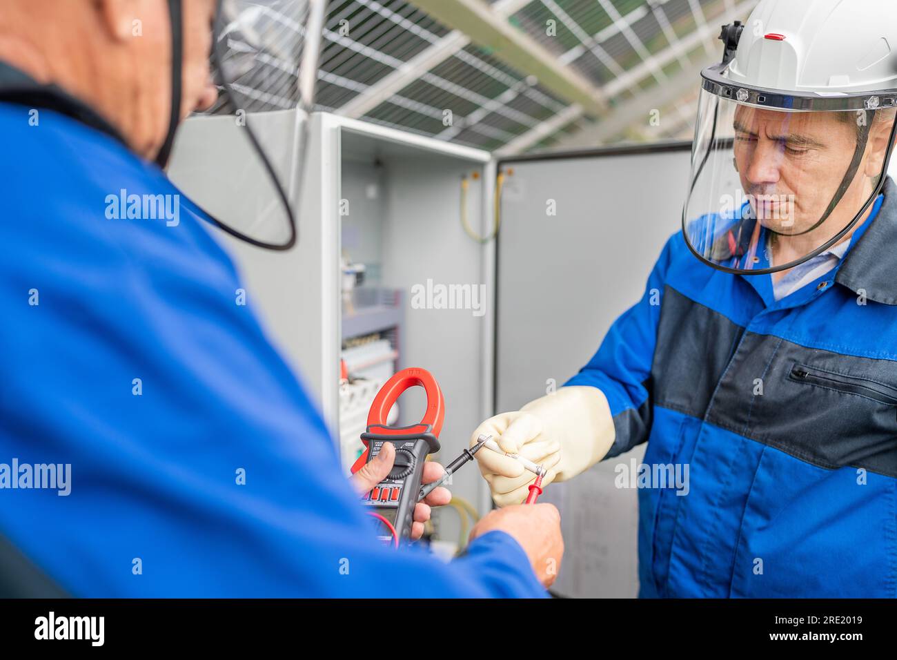 Two Service Engineers or electrician working on checking transformer ...