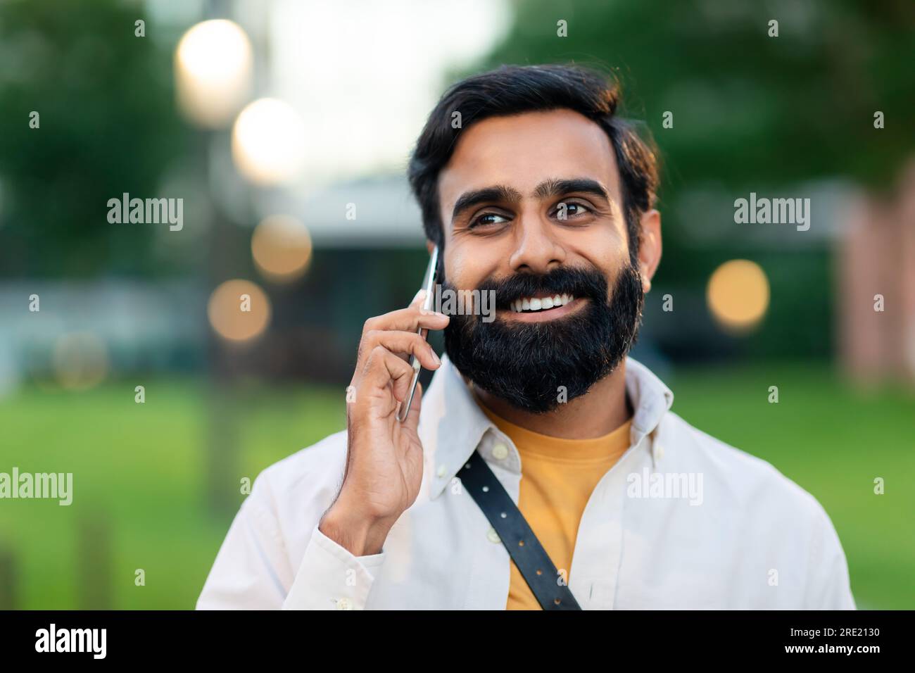Young Indian Man Talking On Cellphone Walking In Urban Area Stock Photo ...
