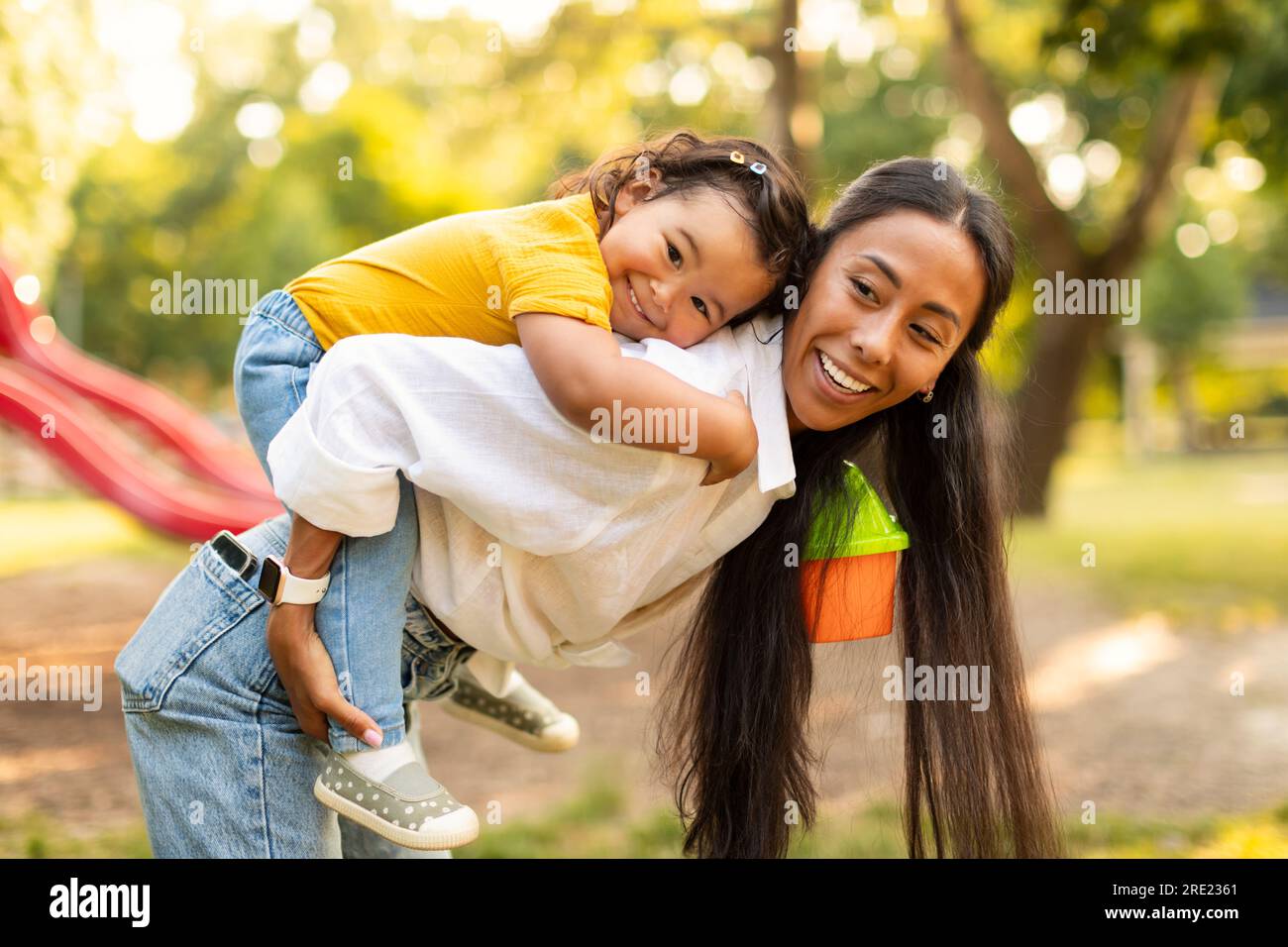 Happy Chinese Mother Giving Piggyback Ride To Baby Outdoors Stock Photo ...