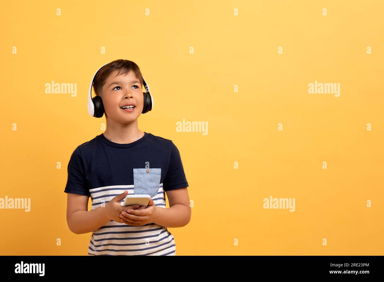Happy kid shool aged boy using wireless headphones and smartphone Stock ...
