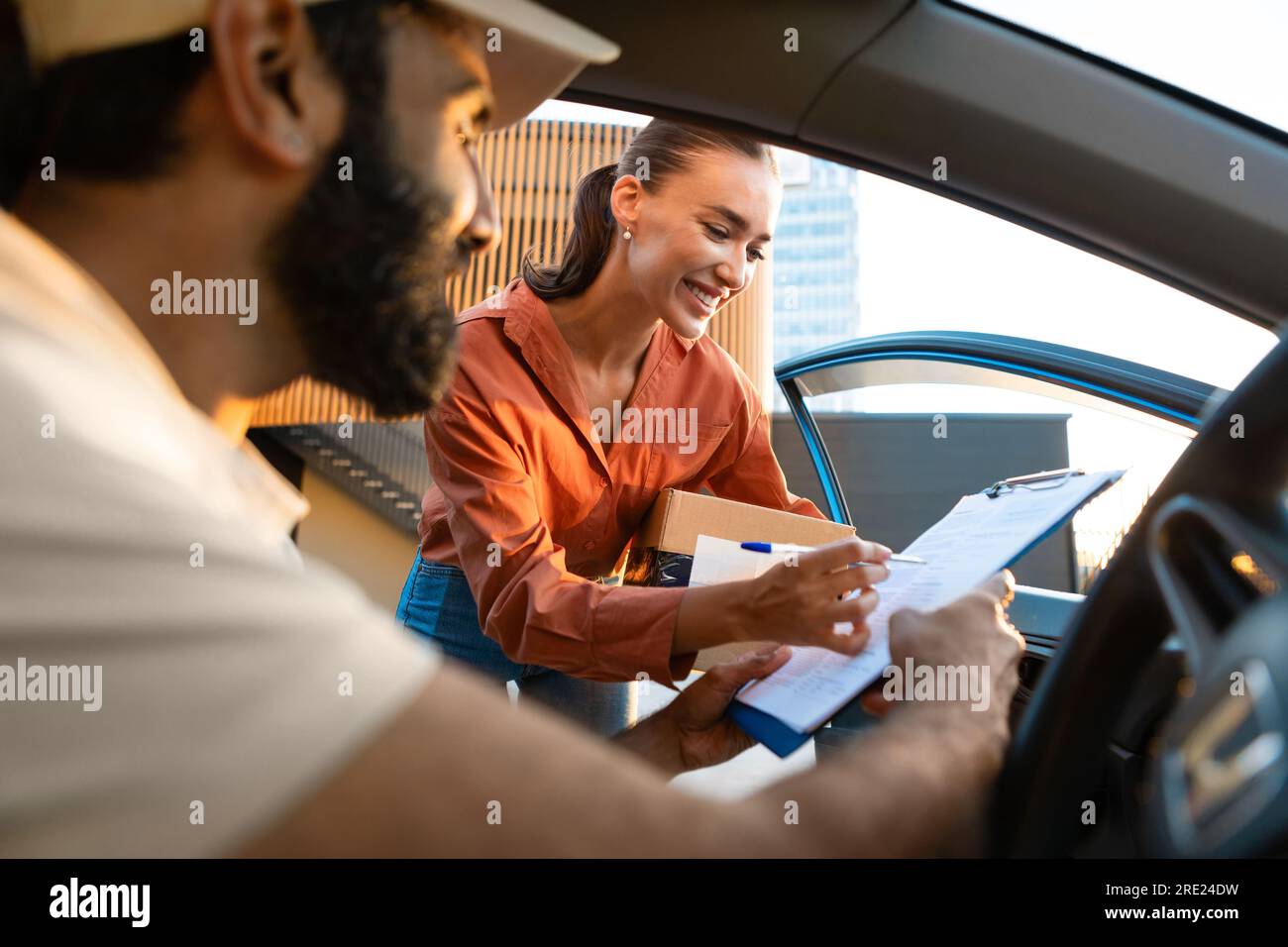 Customer Lady Signing Papers Receiving Parcel From Dliveryman In ...