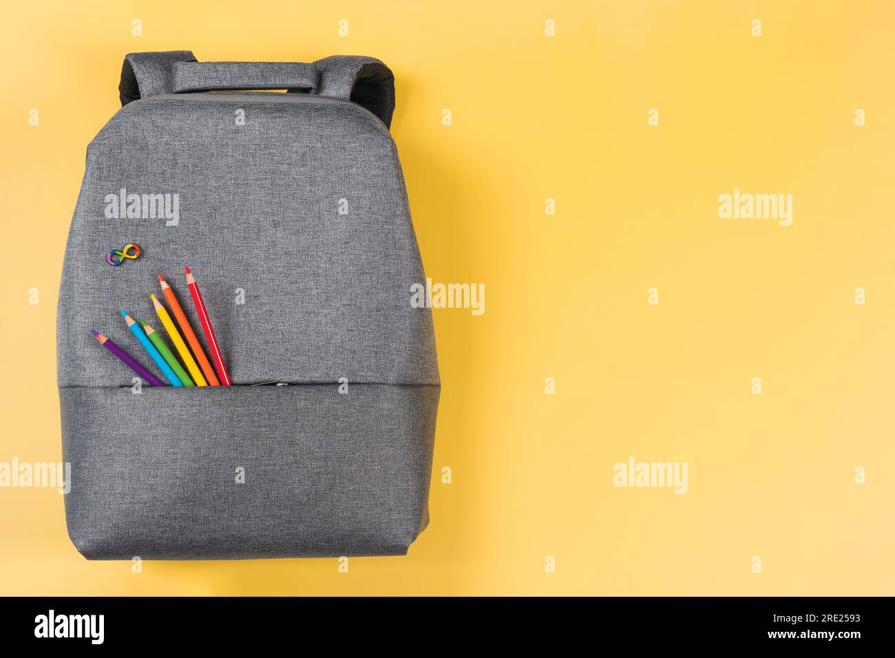 Gray backpack with autism infinity rainbow symbol sign, colored pencils ...