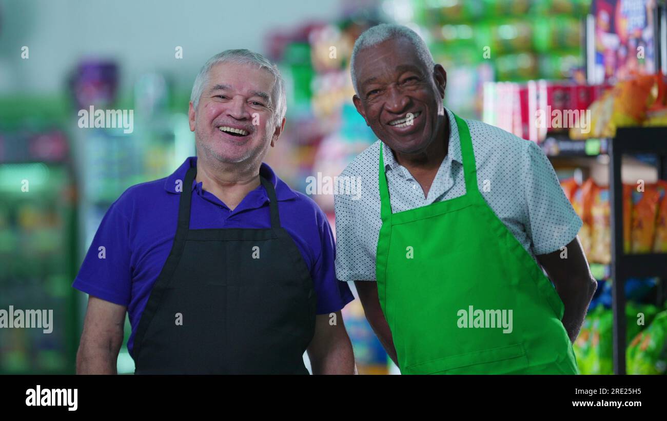 Happy diverse senior workers standing at grocery store smiling at ...
