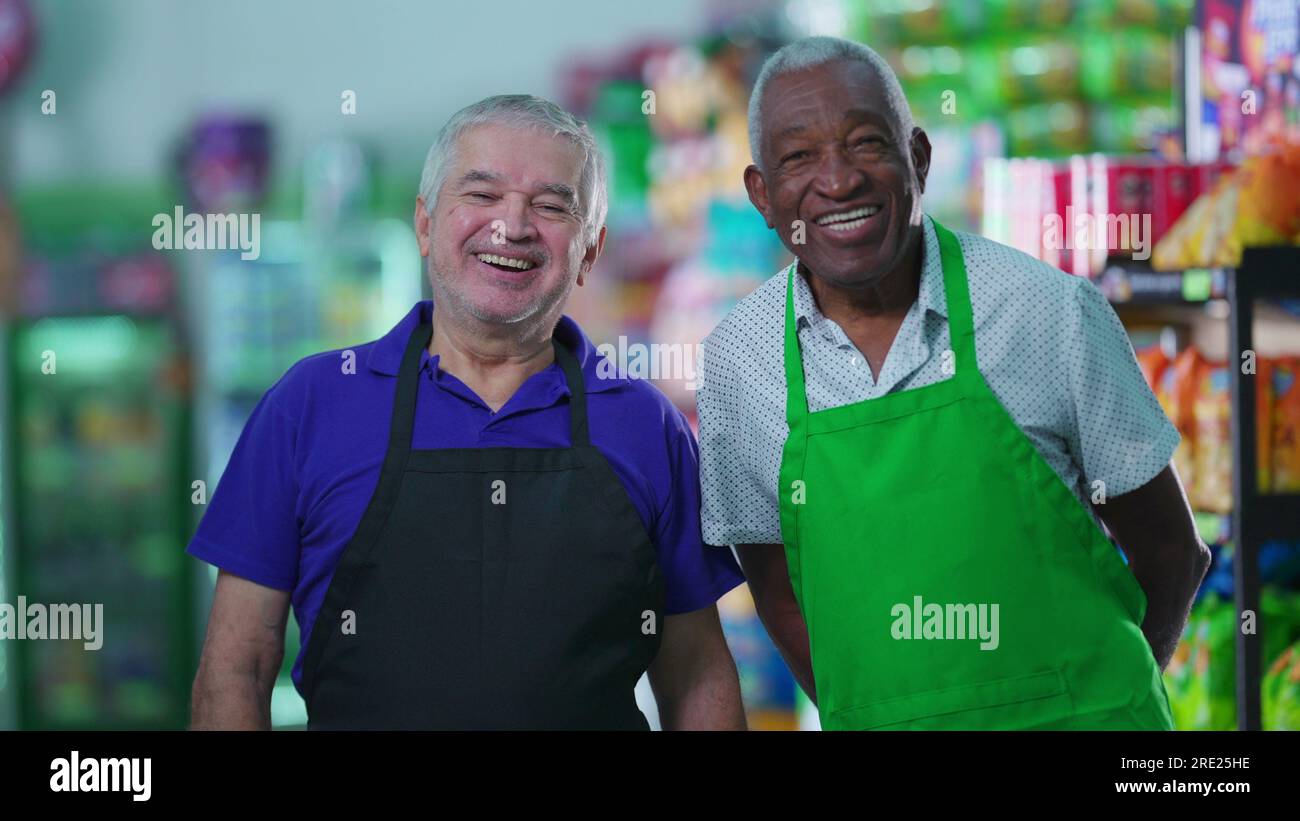 Happy diverse senior workers standing at grocery store smiling at ...