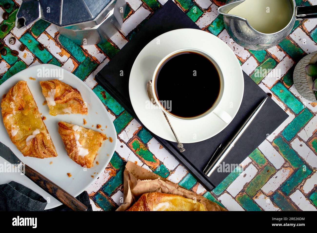 Top view of a cafe scene, with black coffee in a white cup and saucer ...