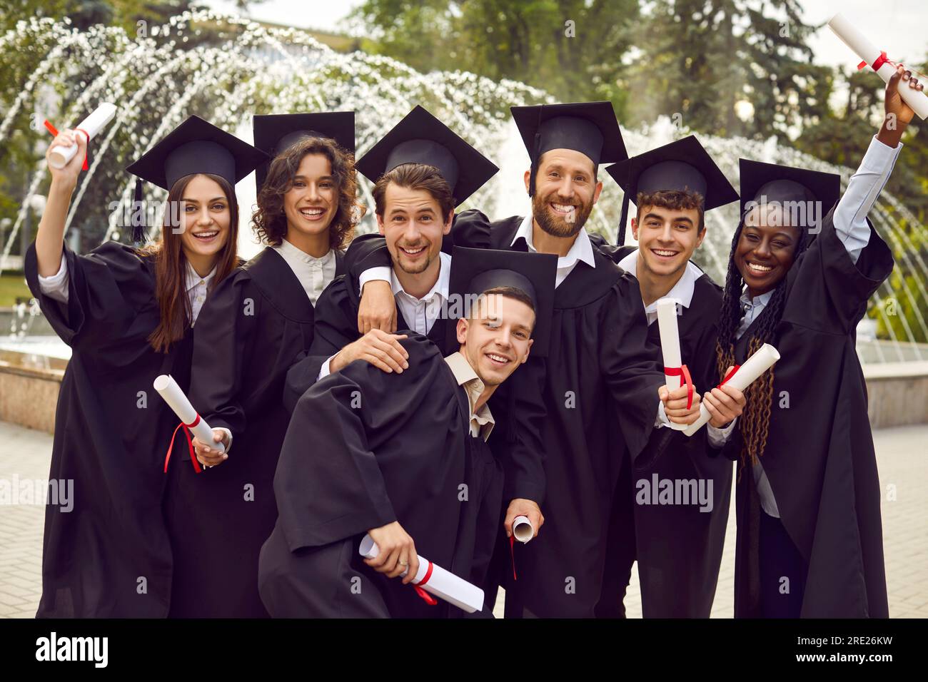 Group photo of happy multiethnic university friends with diplomas on ...