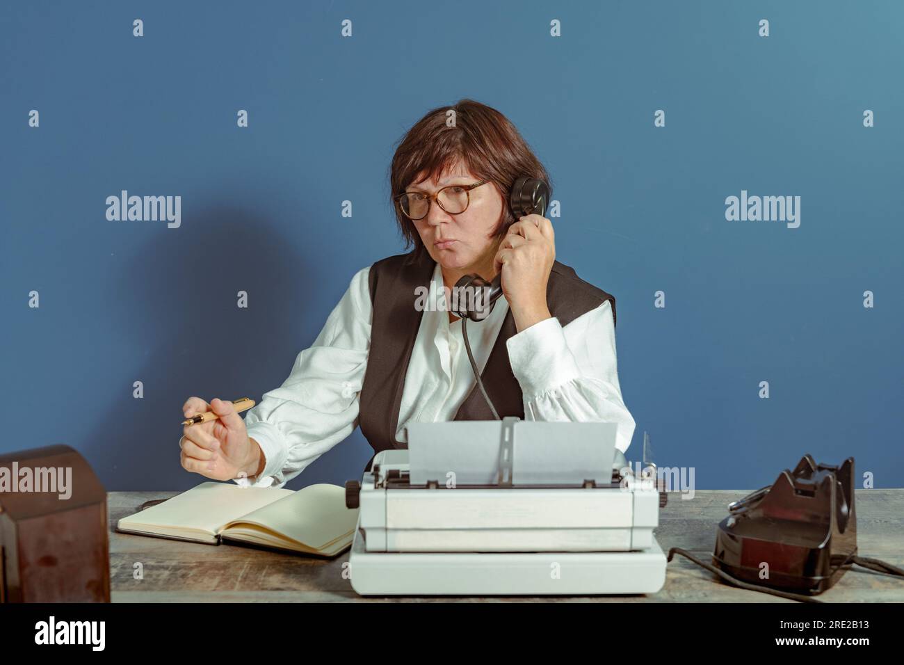 Brunette secretary from the past at work. Vintage concept. Table with ...