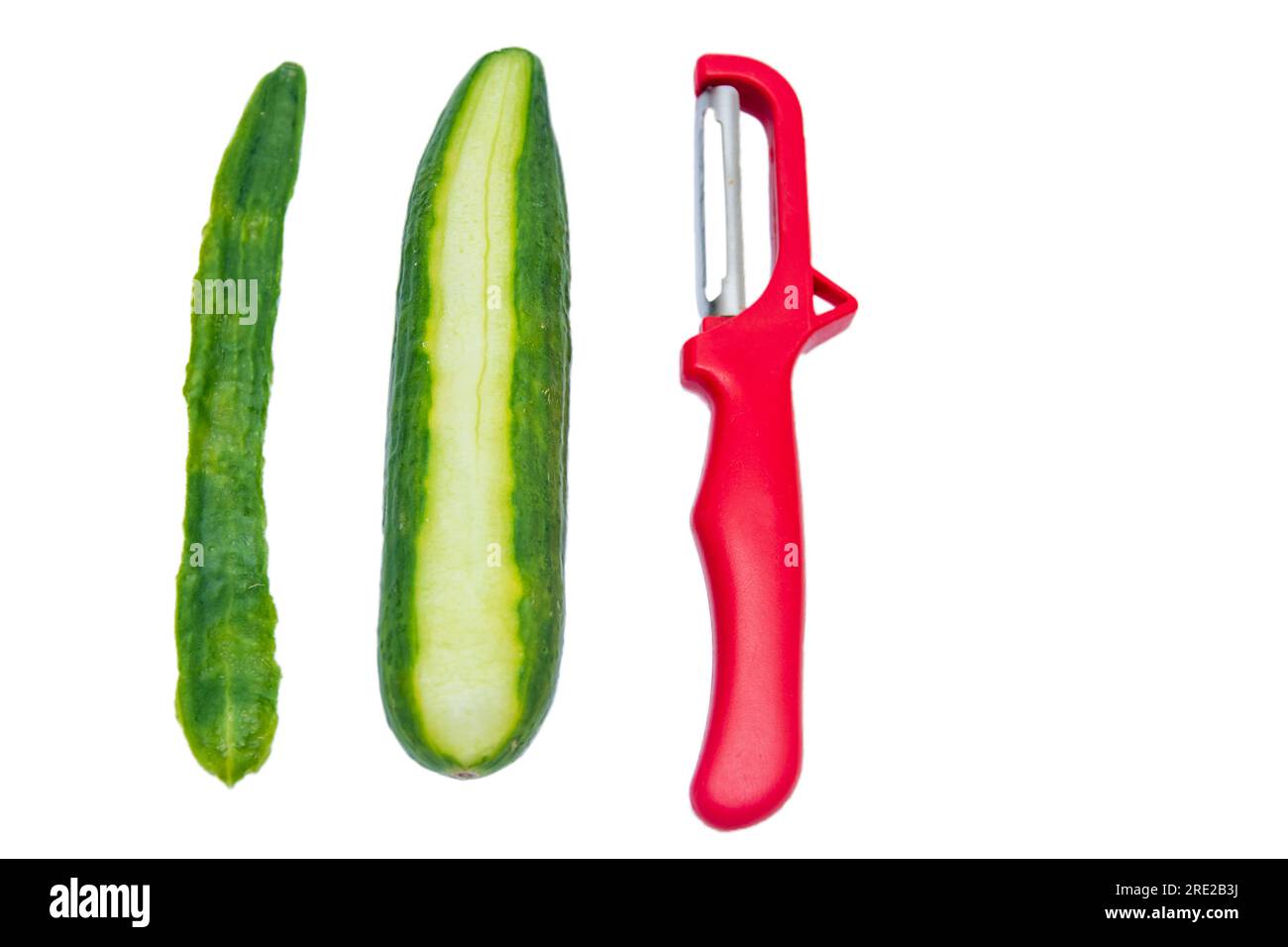Cucumber, cucumber peel and peeler knife on white isolated background ...