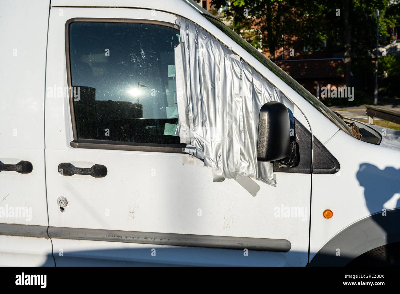 Taped up side window of a white van on a parking lot Stock Photo - Alamy