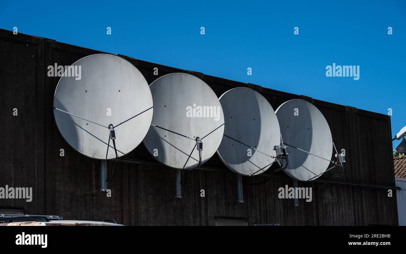 Four parabolic antennae on the facade of a building Stock Photo - Alamy