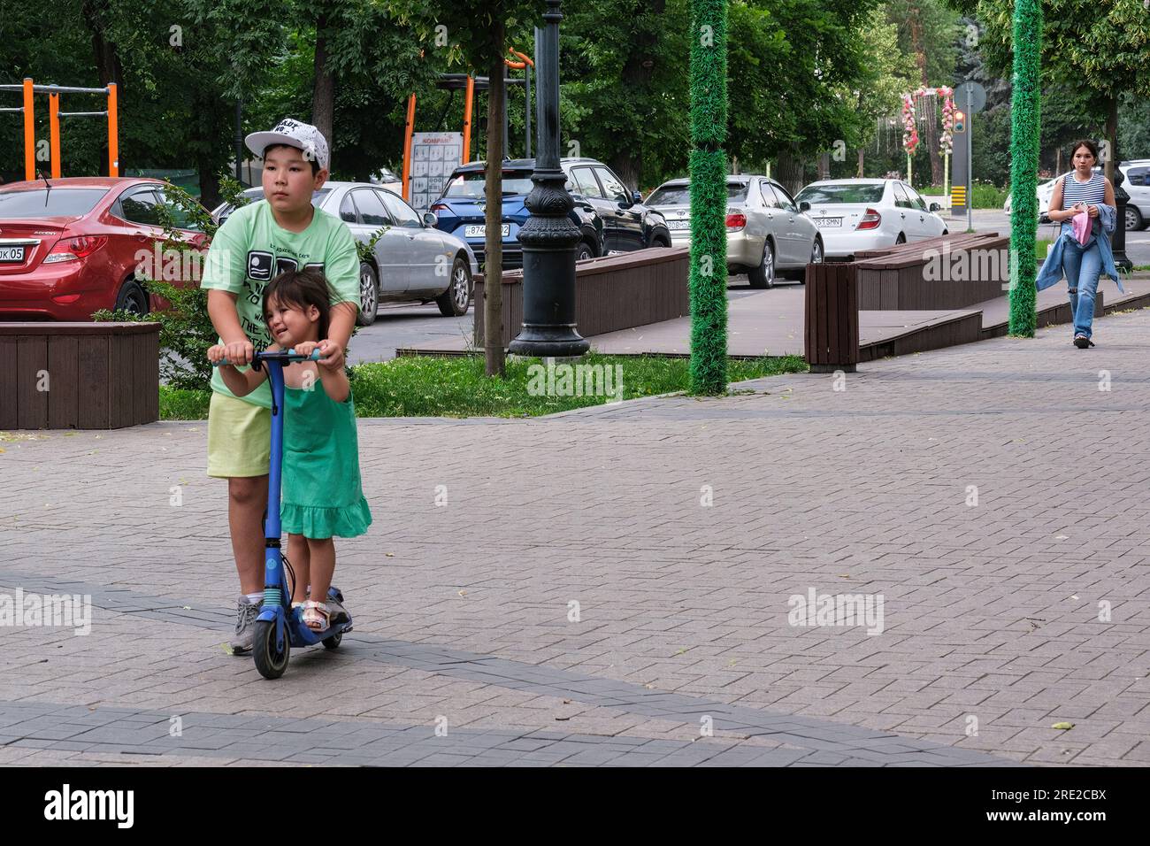 Kazakhstan, Almaty. Boy and Little Sister on Scooter on the Panfilov ...