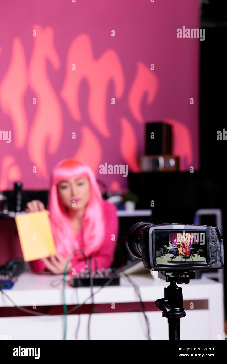 Content creator sitting at desk in vlogging studio recording school ...