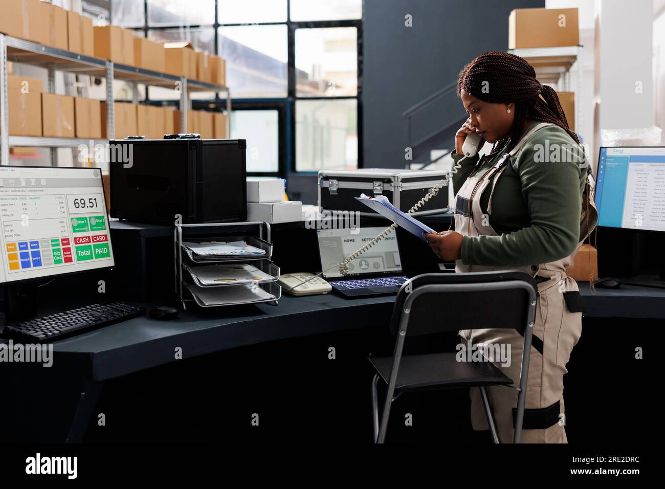 African american employee holding clipboard, analyzing goods inventory ...