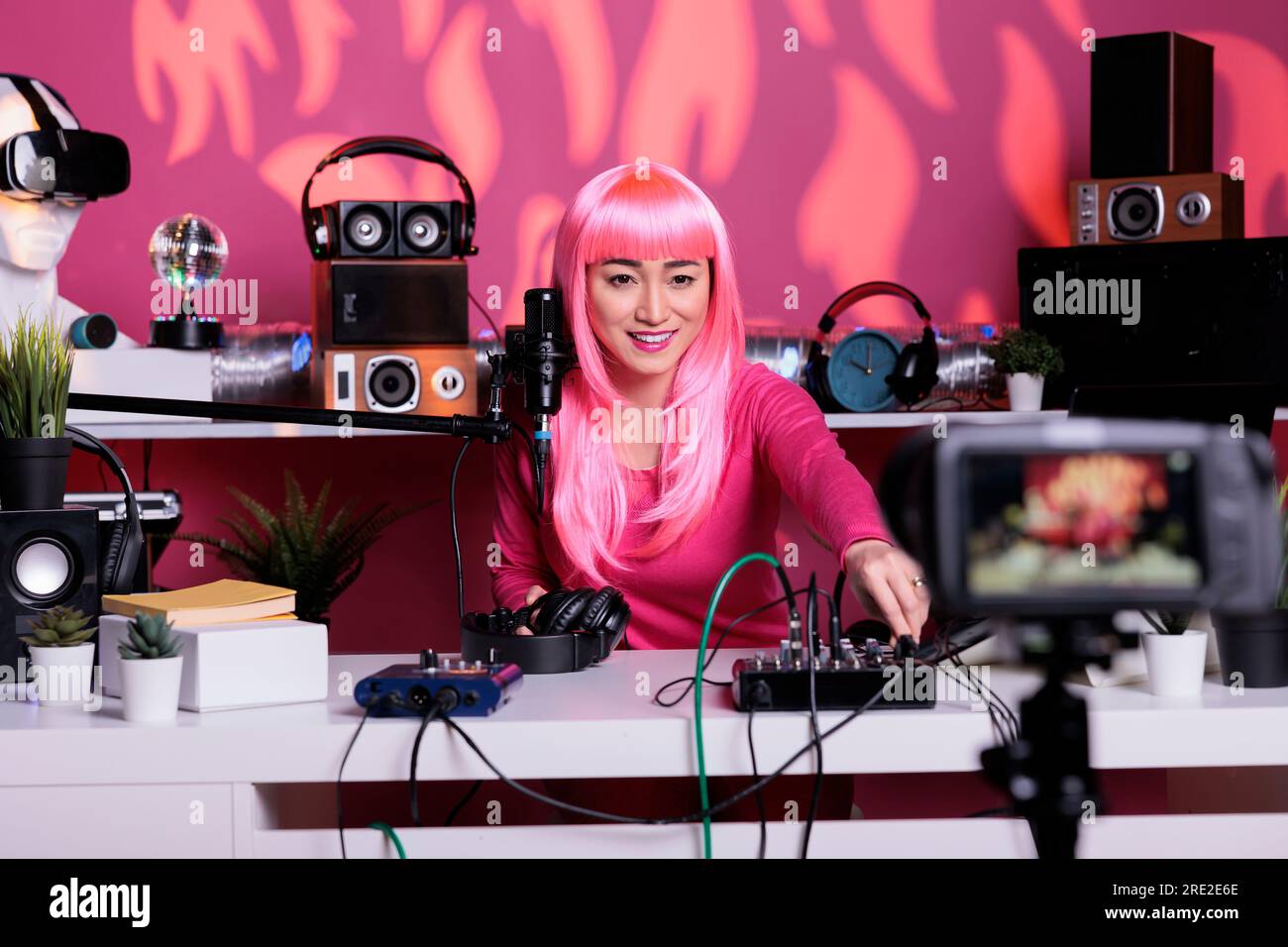 Influencer with pink hair recording vlog talking with subscribers using ...