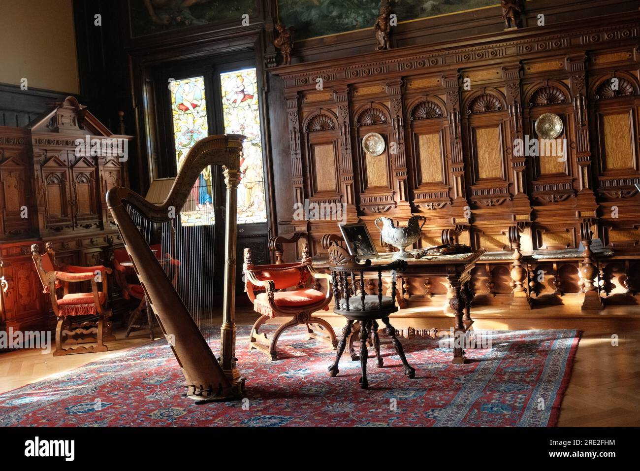 A beautifully arranged music room featuring an elegant harp, nestled ...