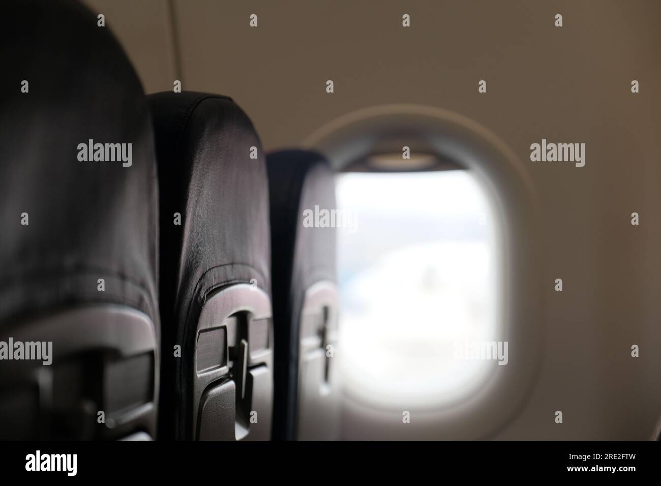 A cinematic shot from inside an airplane, focusing on three seats and a ...