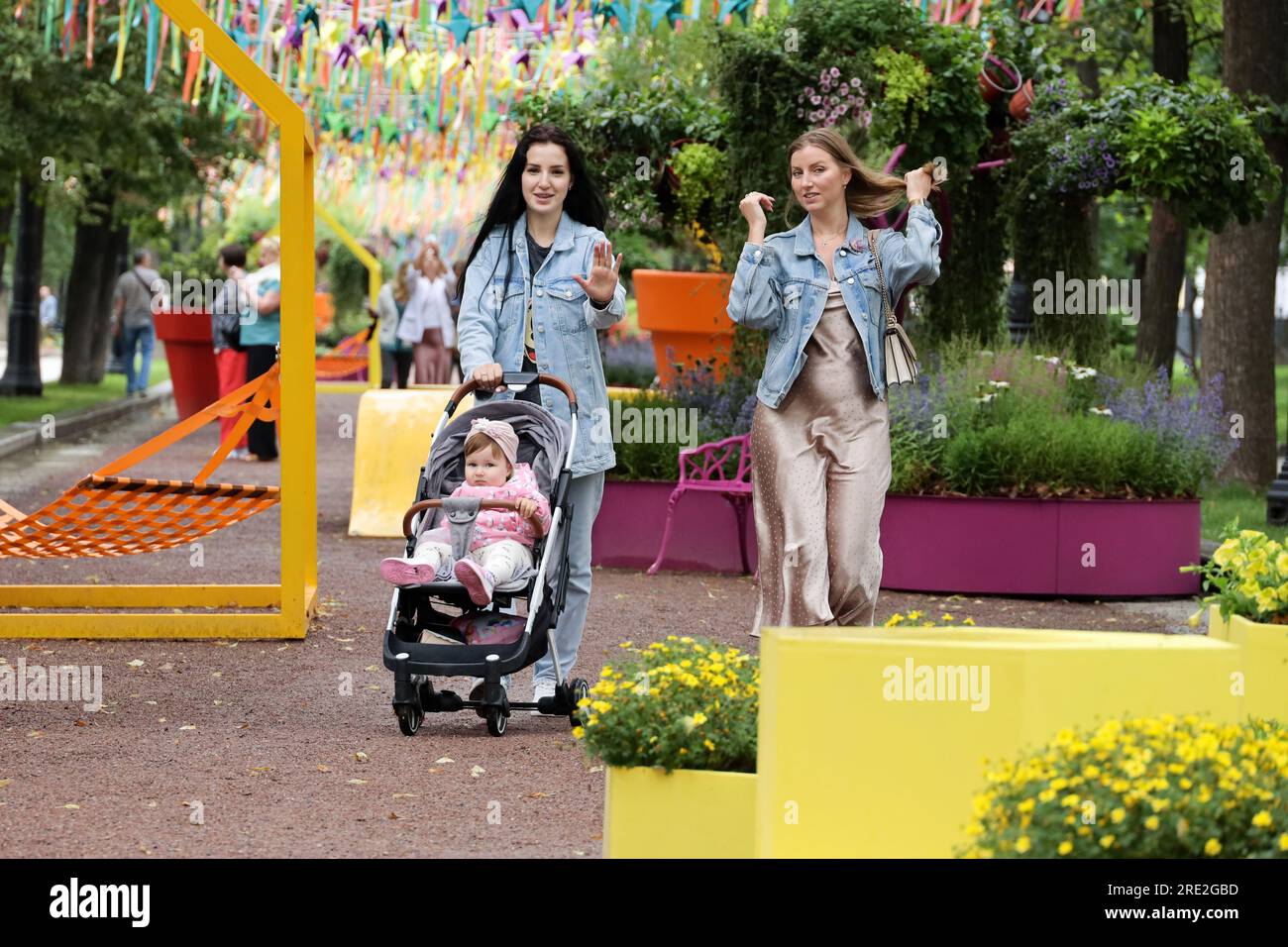 Two young women walking with baby pram on Tverskoy boulevard in summer ...