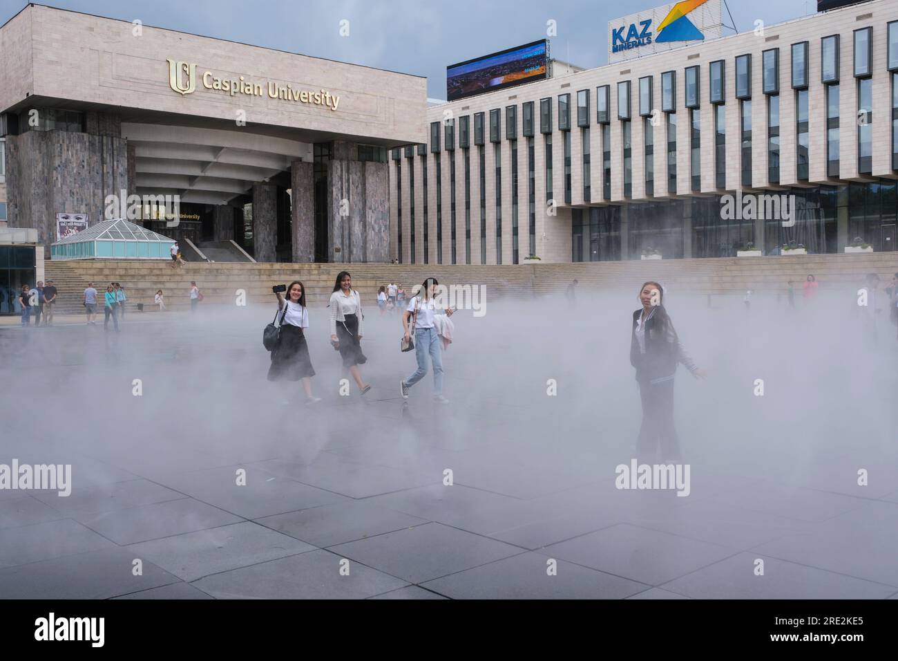 Kazakhstan, Almaty. Students Walk through "Fog Fountain" in front of ...