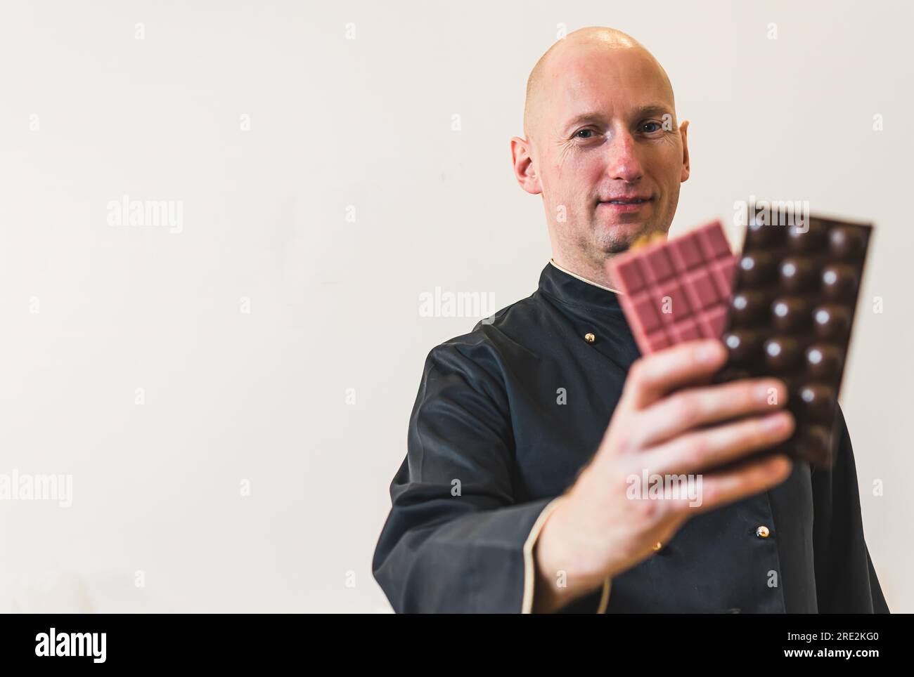 Bald caucasian middle aged chef dressed in black professional chef ...