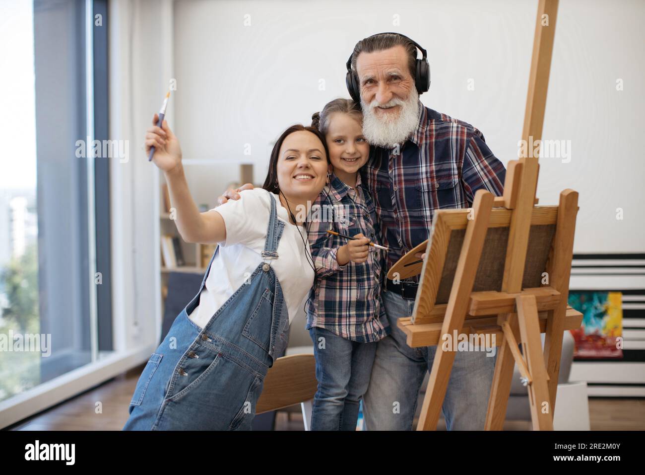 Portrait of cheerful creatives in listening devices using design tools ...