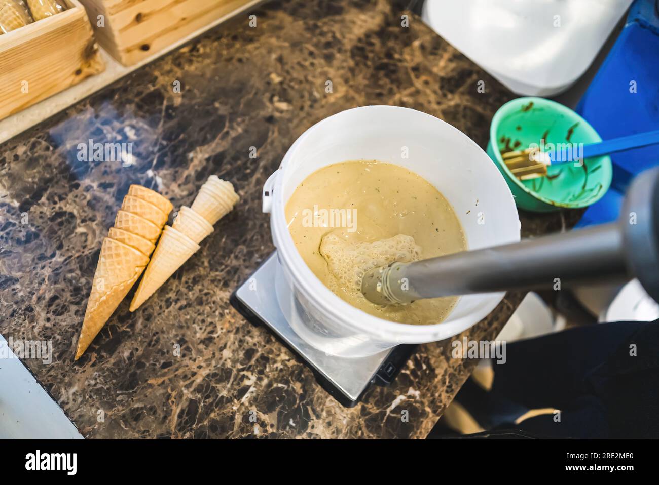 Closeup of professional blender whisking ice cream. Bucket of bright ...