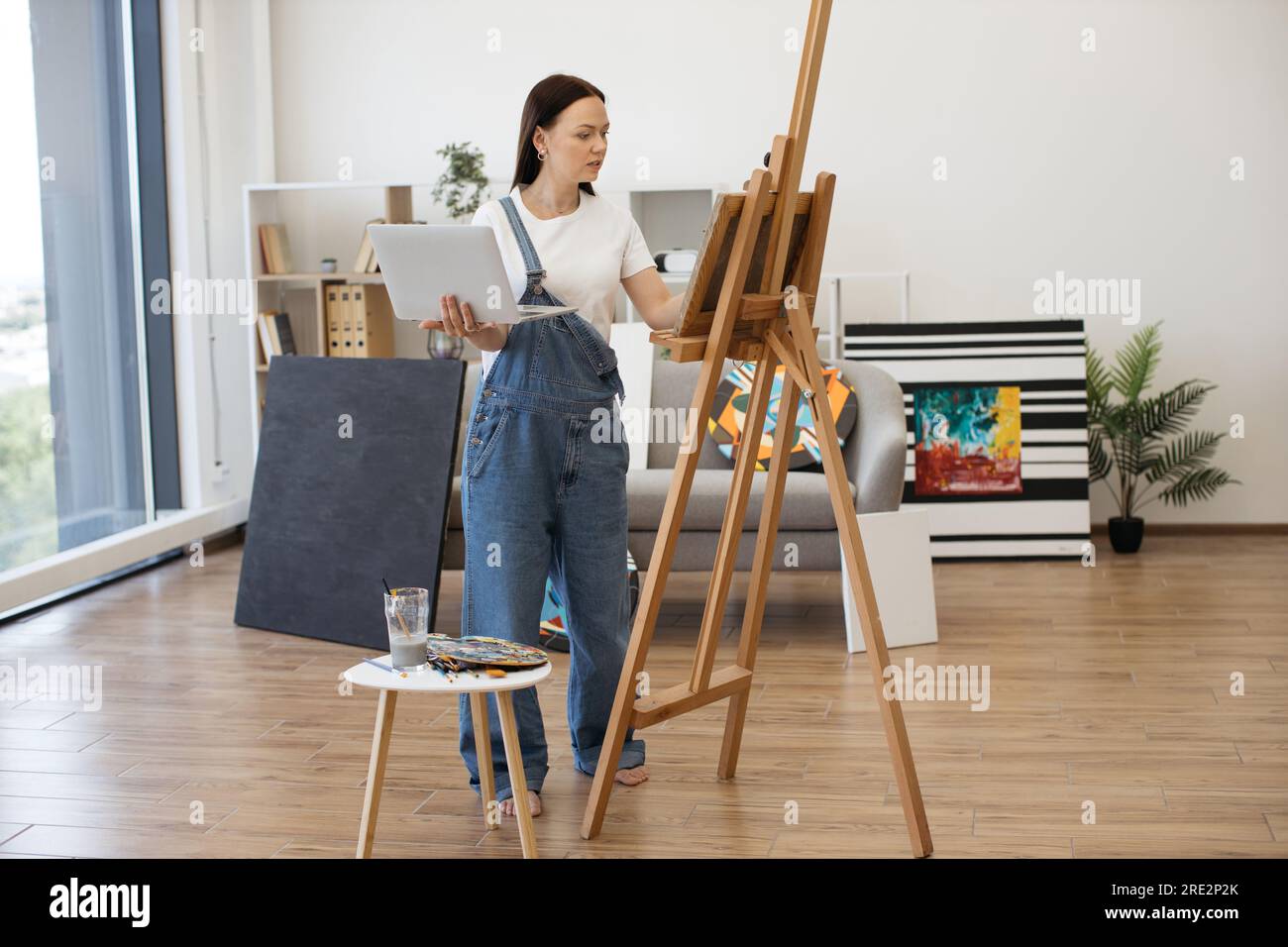 Female professional painter having video conference using portable ...