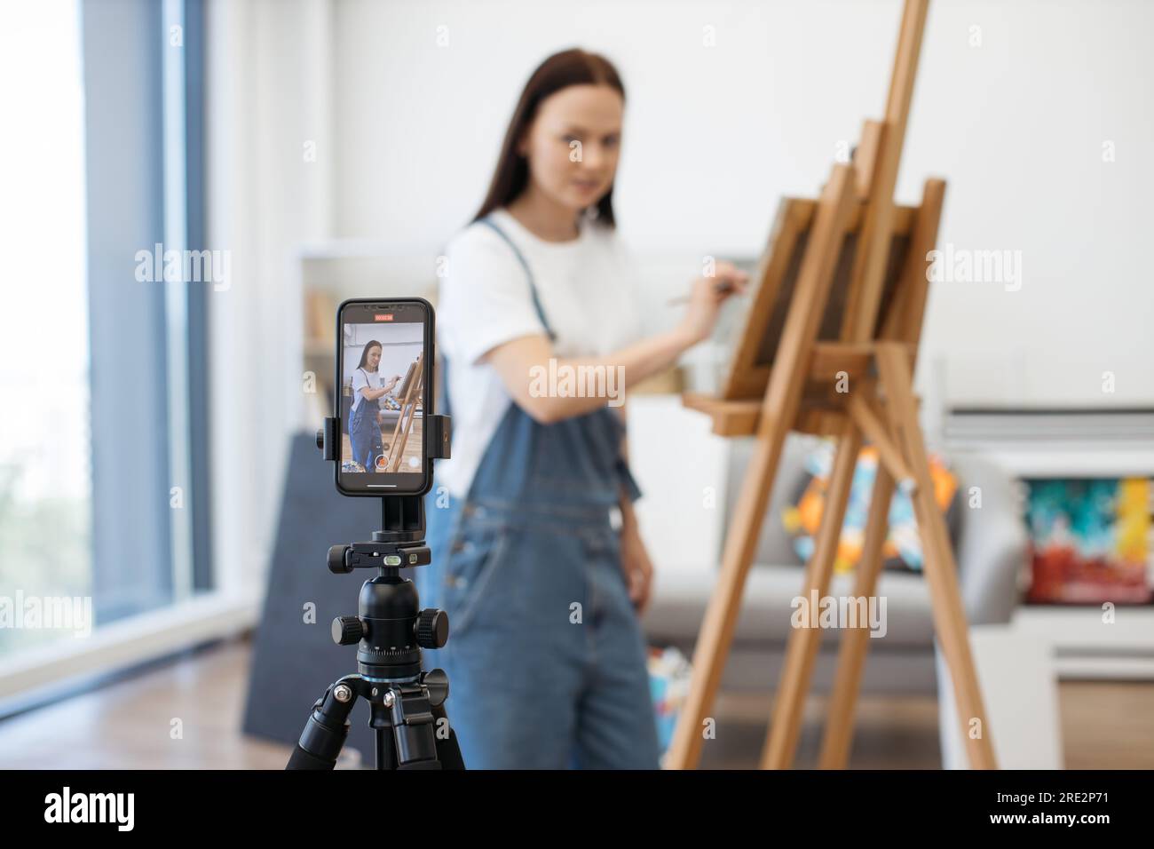 Professional female artist recording video on camera of personal ...