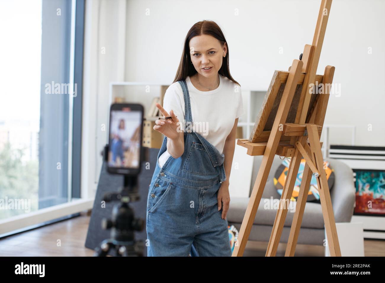 Professional female artist recording video on camera of personal ...