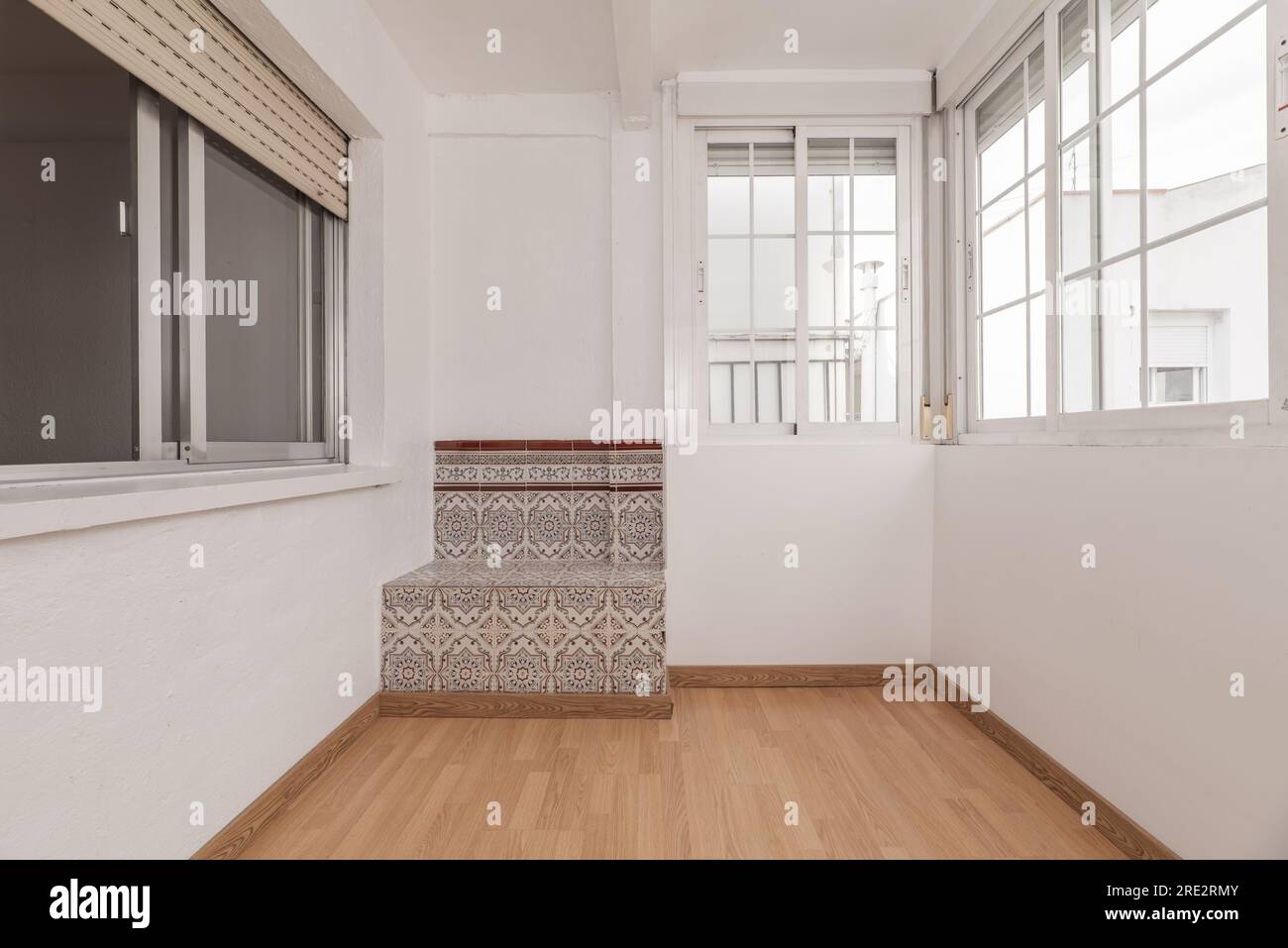 Closed terrace with white aluminum glazing windows and a tiled seat ...