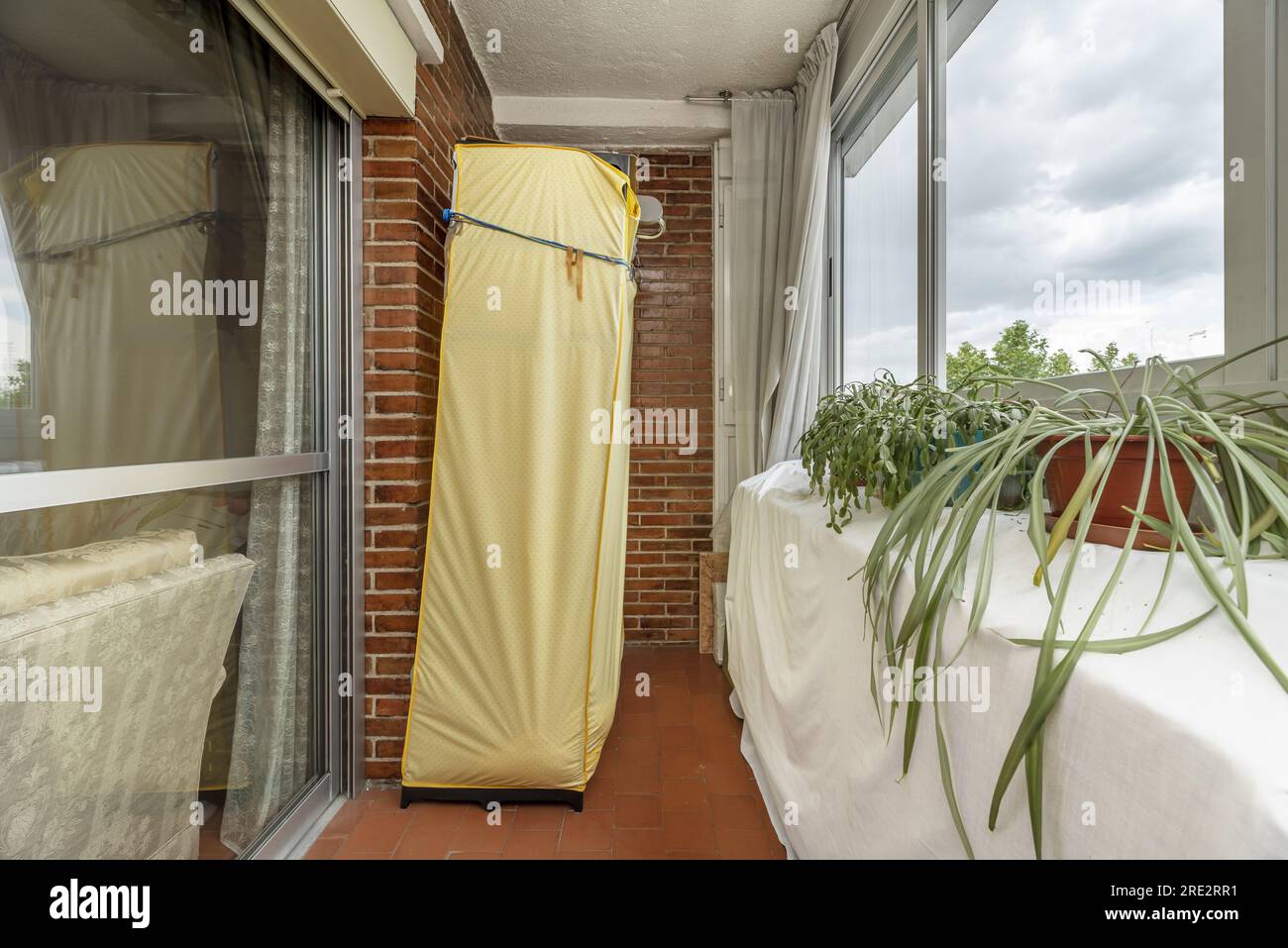 closed terrace of a house with brown clay floors, fabric wardrobe and ...
