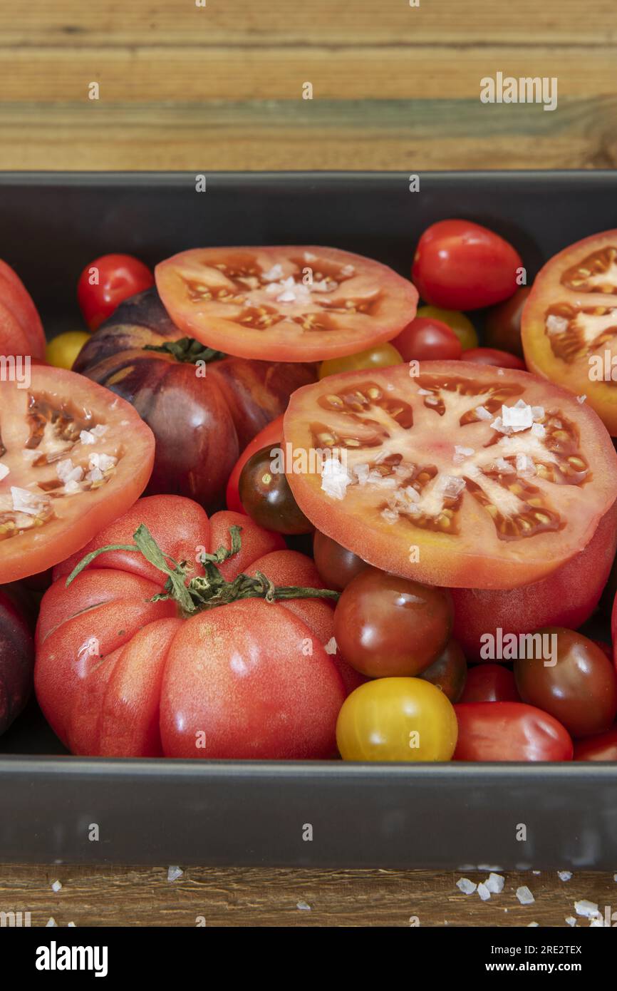 Some delicious looking ripe tomatoes next to some tomato slices with ...