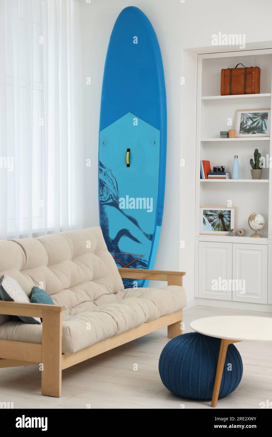 SUP board and modern furniture in stylish living room. Interior design ...