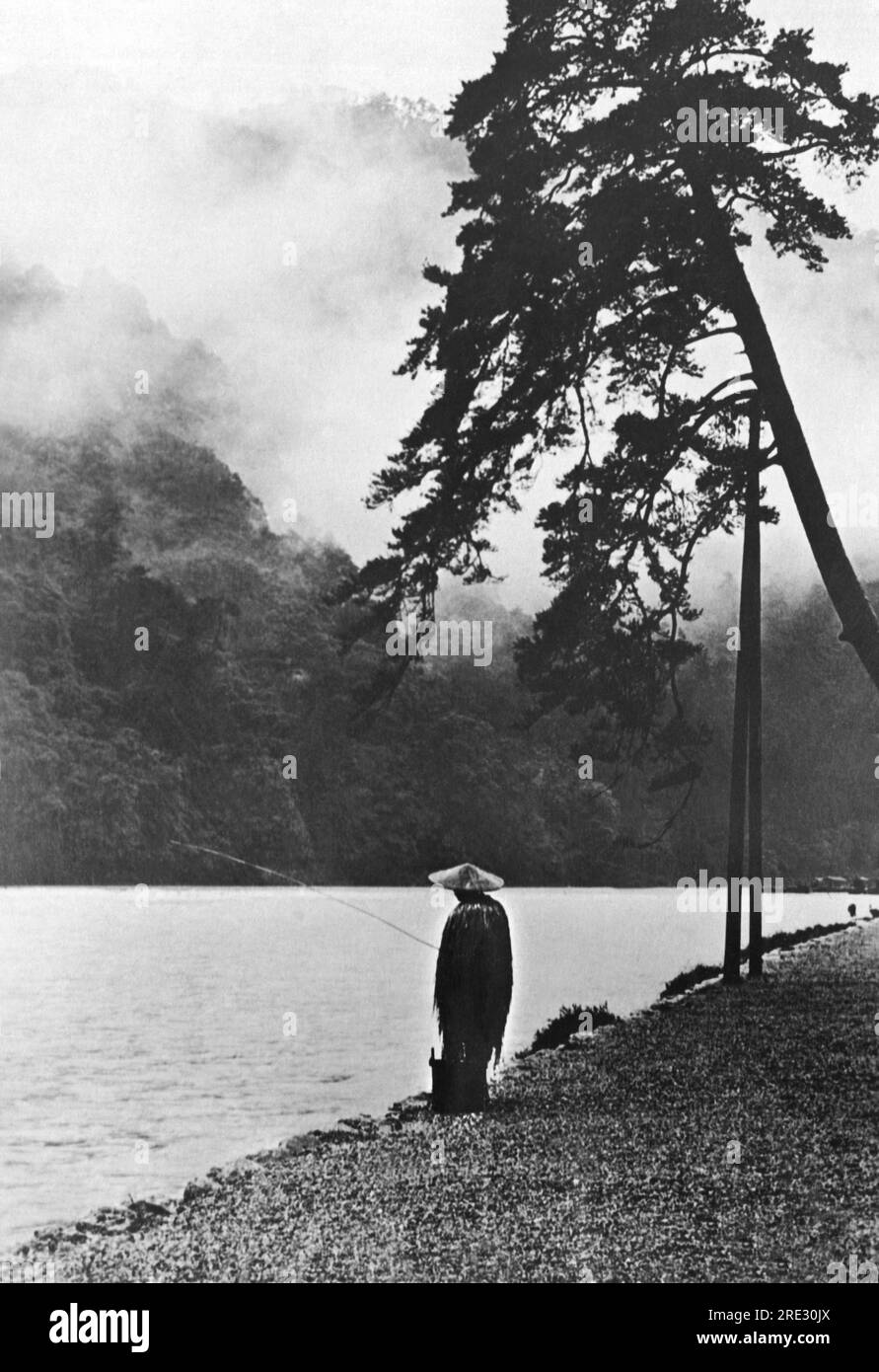 Japan: November 5, 1922 A lone fisherman in the plaited straw raincoat ...
