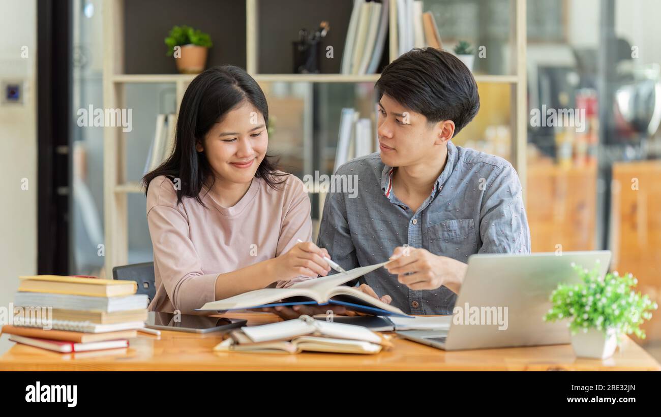 Two Asian students learning together and tutor together at cafe Stock Photo - Alamy