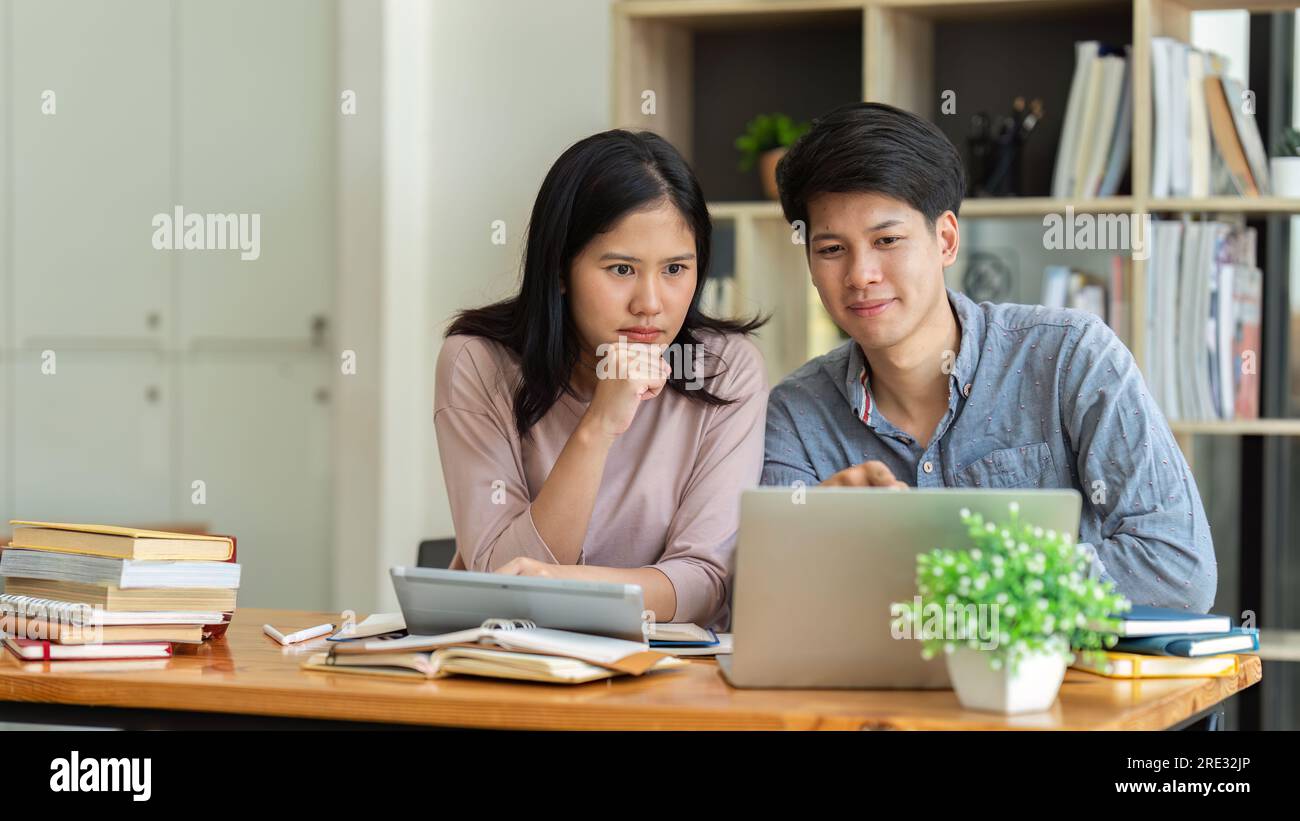 Two Asian students learning together and tutor together at cafe Stock ...