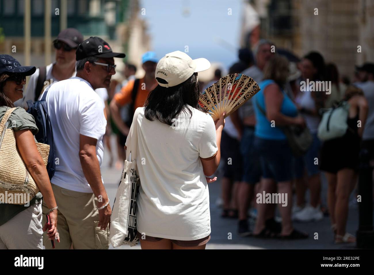 Valletta, Malta. 24th July, 2023. A woman cools herself with a fan in ...