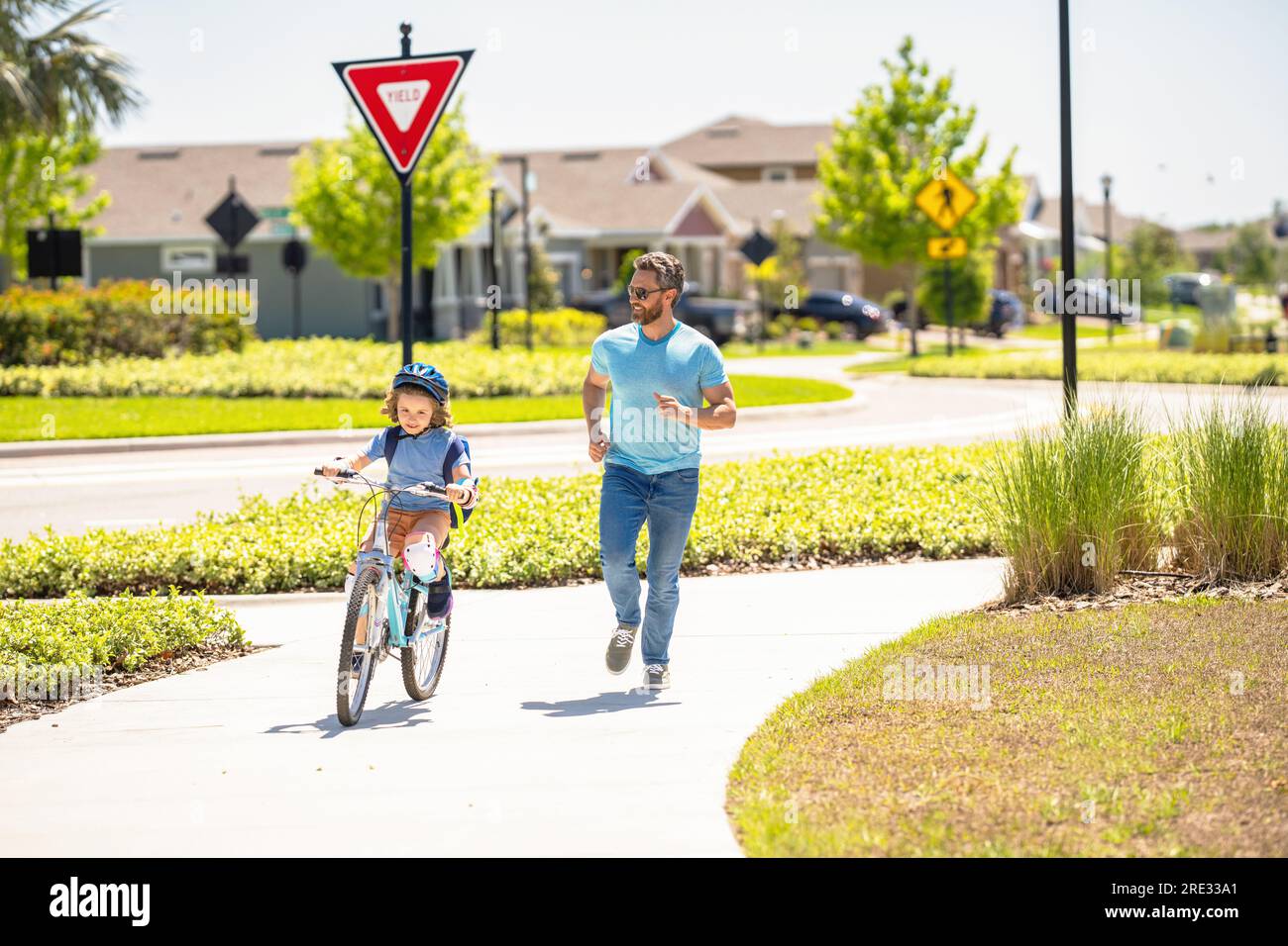 father and son on bicycle at fathers day. father setting a example for ...