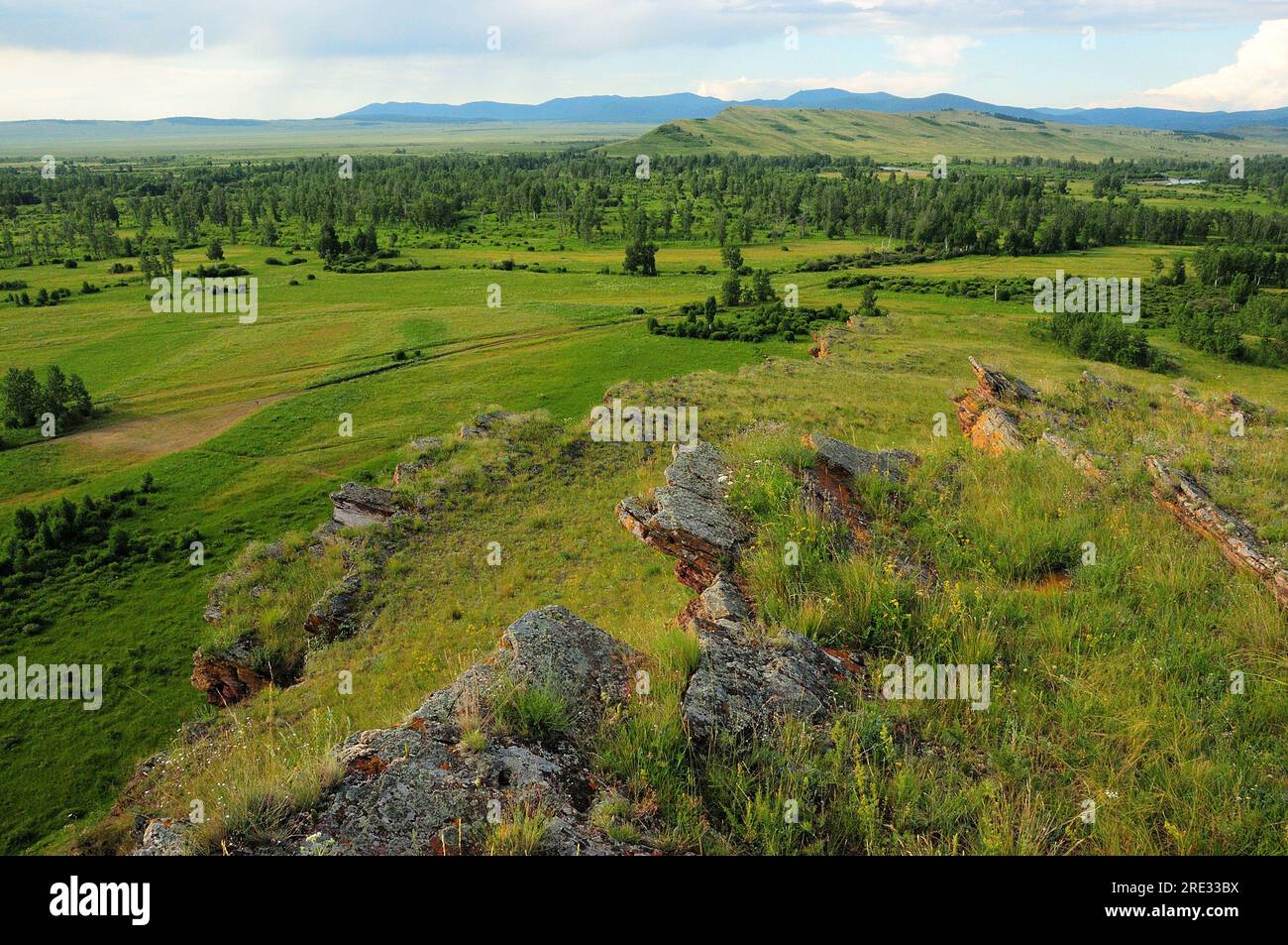 Pointed rock formations of red stratified sandstone on top of a gentle ...