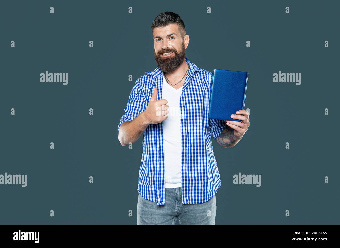bearded man recommend book on grey background. thumb up Stock Photo - Alamy