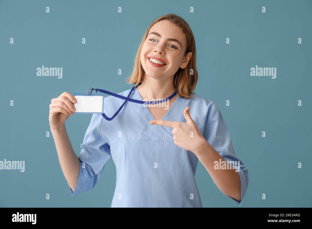 Female intern with badge on blue background Stock Photo - Alamy