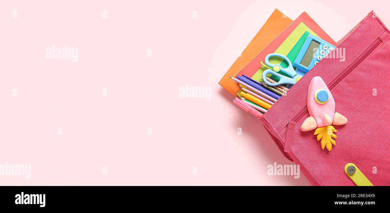 Backpack with rocket made of plasticine and stationery on light pink ...