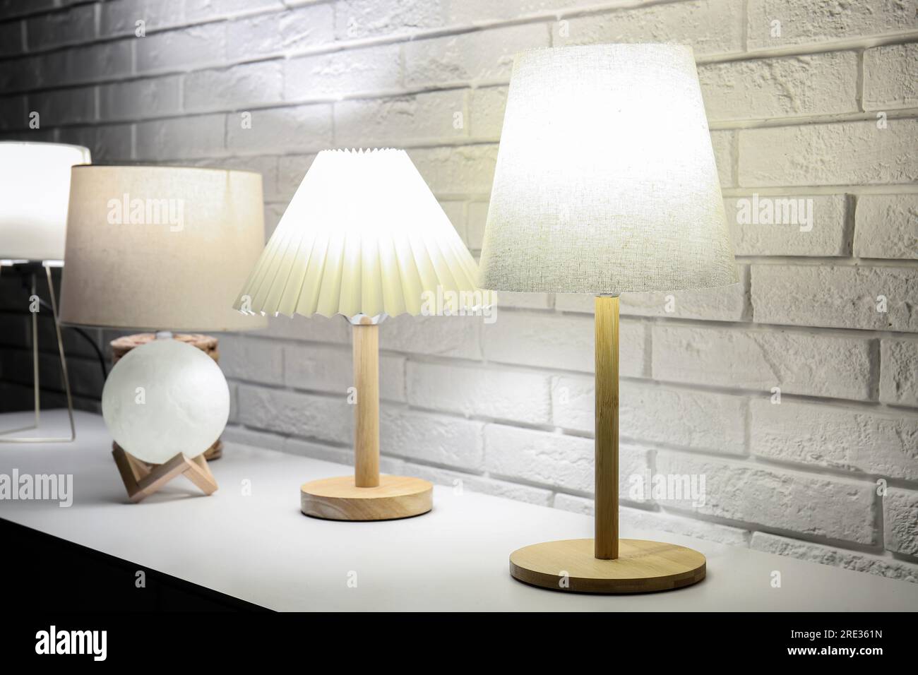 Different glowing lamps on table in dark room Stock Photo - Alamy