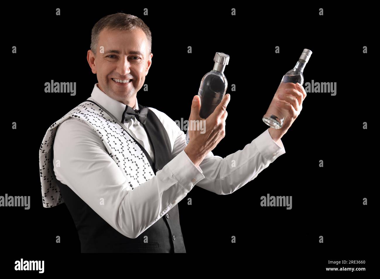 Mature waiter with bottles of vodka on black background Stock Photo - Alamy